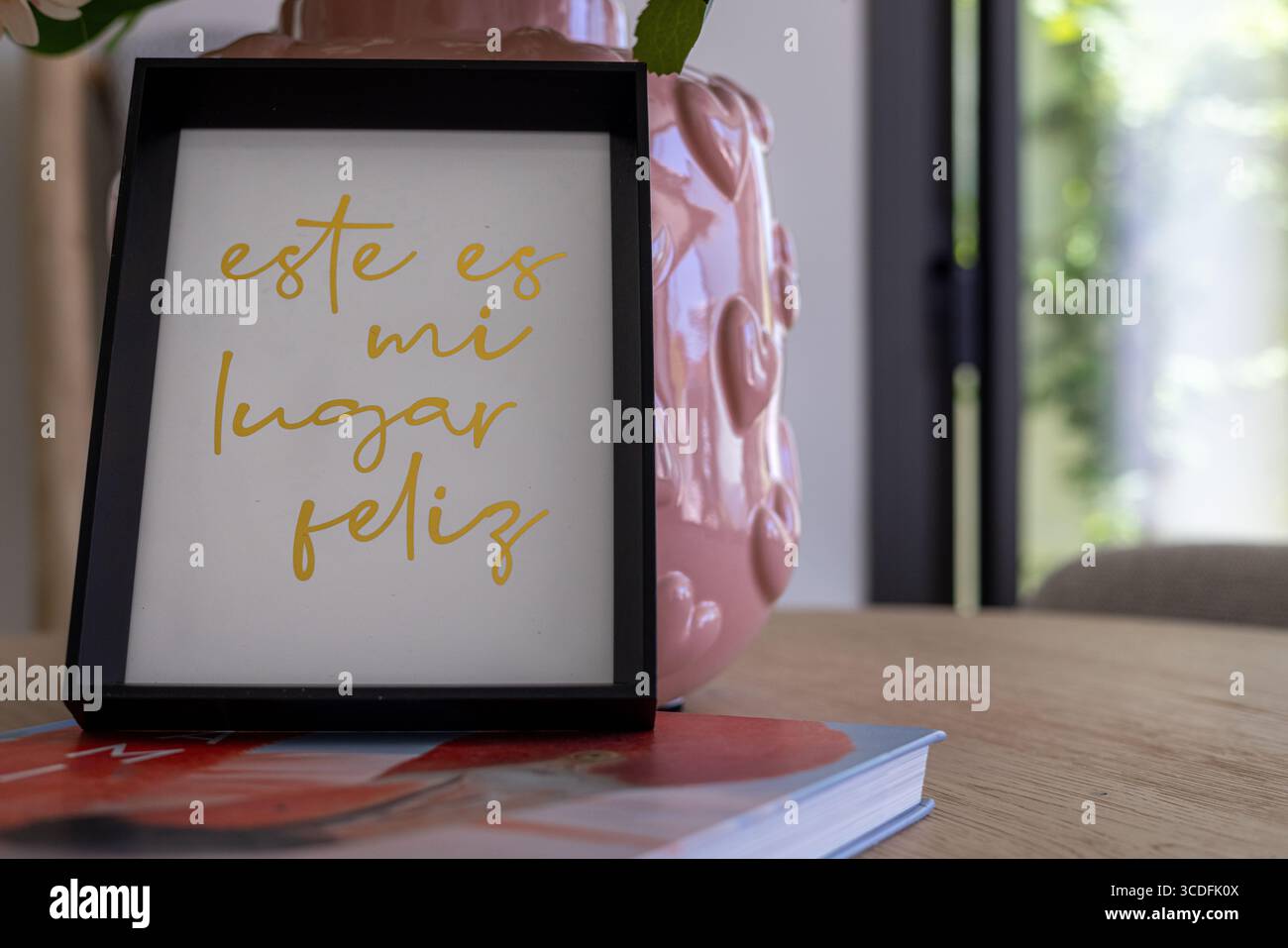 Decorative frame with quote 'este es mi lugar feliz' next to a pink ...
