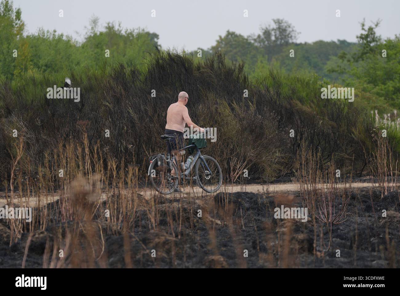 A man cycles past the aftermath of a fire in Wanstead Flats, north-east ...