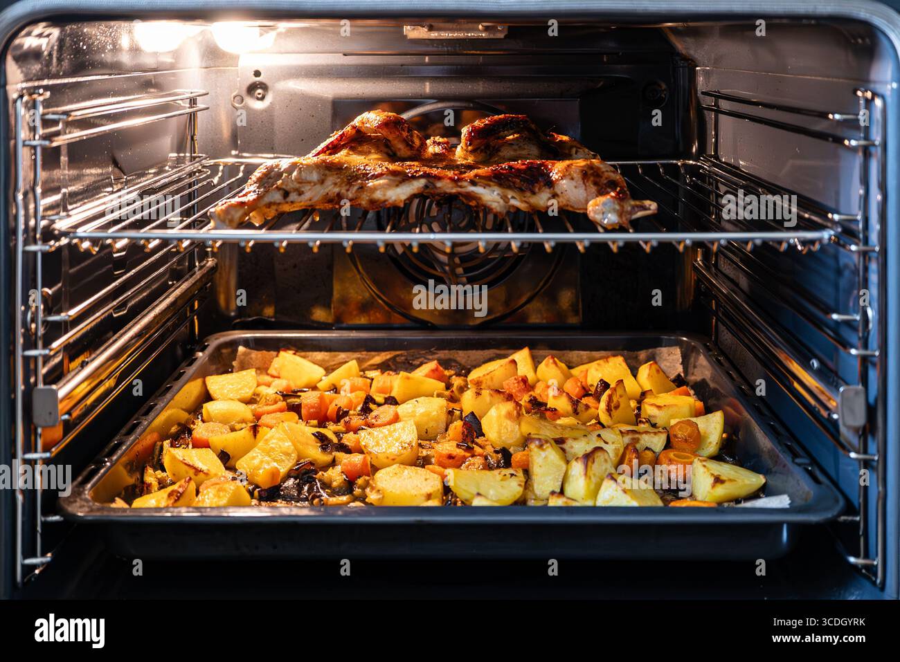 Ready-made chicken tabaka with potato cookies in the oven Stock Photo ...