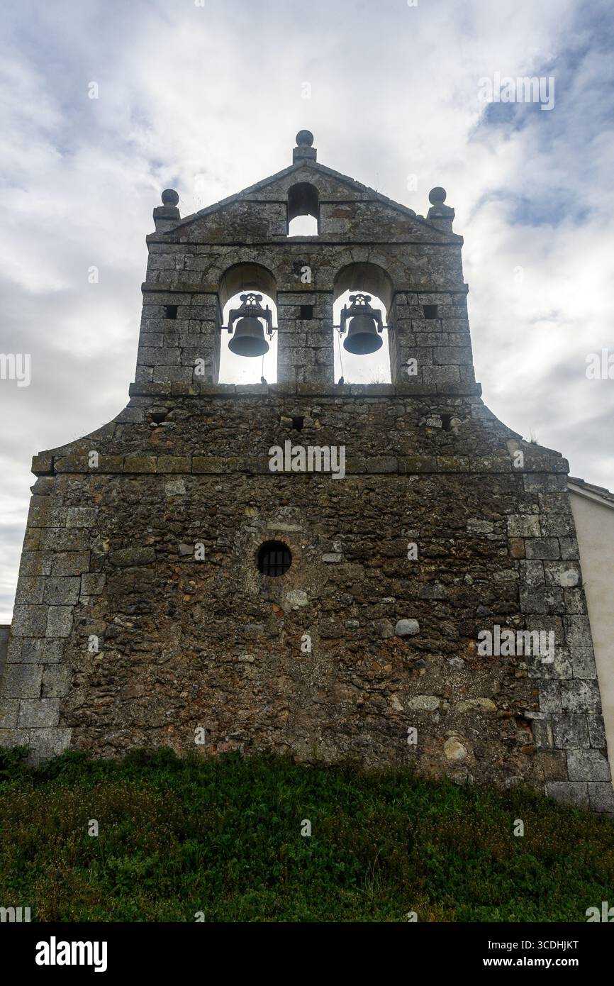 Ancient Romanesque stone bell gable with two bells on a grassy hill ...