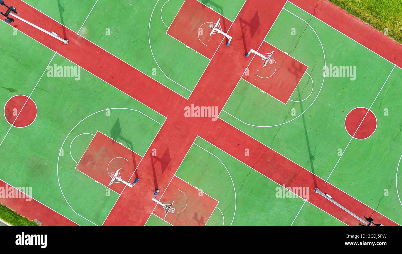 Aerial view of multiple vibrant outdoor basketball courts with red and ...