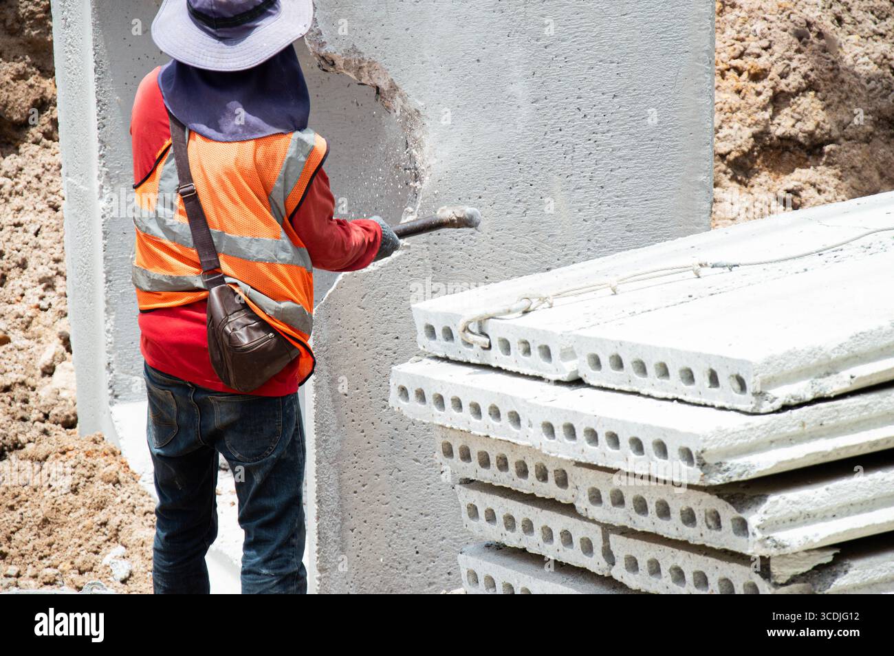 Workers are using hammers to break concrete blocks at a construction ...