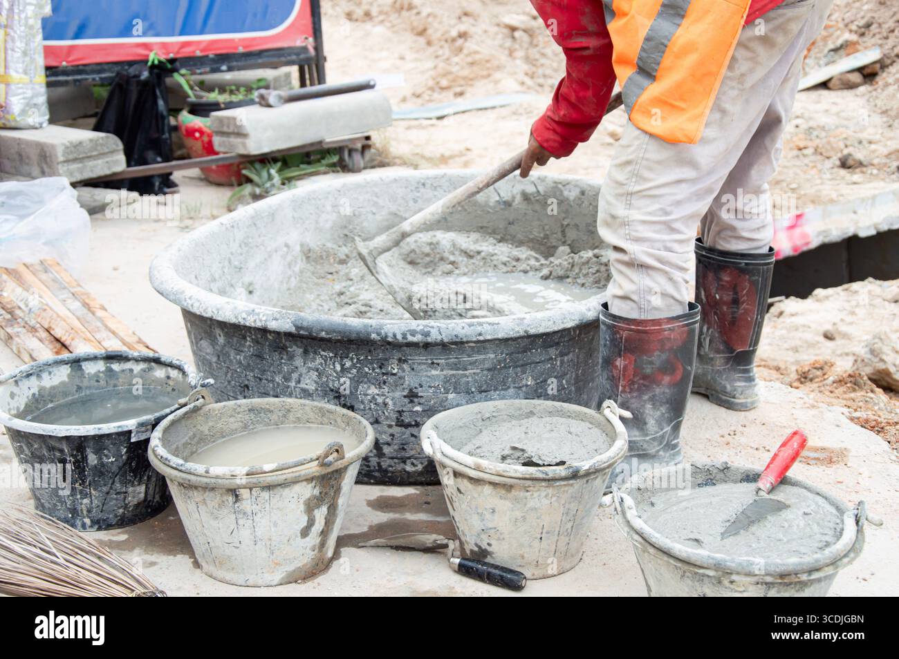 Workers are mixing cement in a mixing tank at a construction site Stock ...