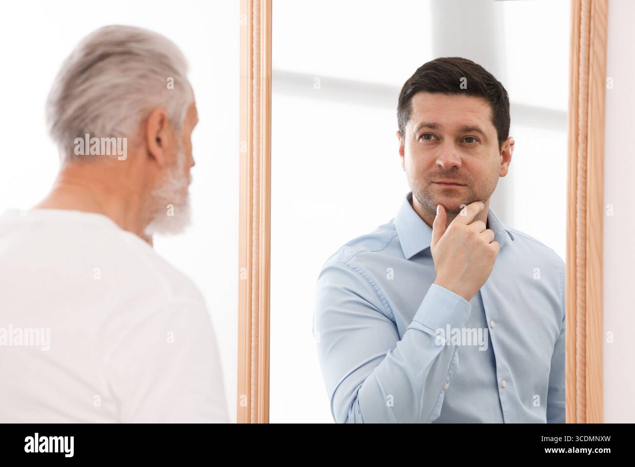 Senior man seeing himself younger in mirror. Conceptual collage about ...