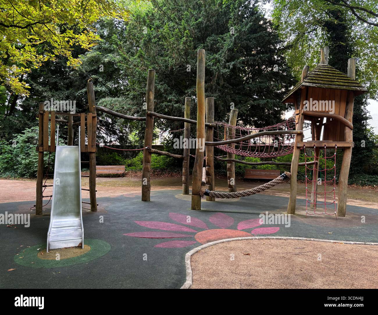 Kids playground in city park with slide, climbing nets, rope bridges ...