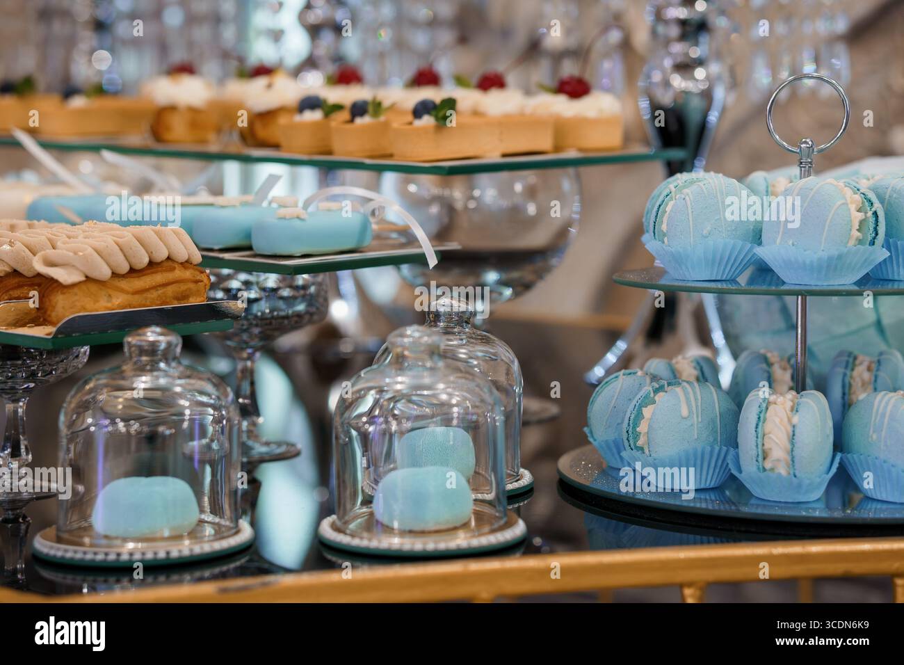 An exquisite dessert buffet spread showcases delicate blue macarons ...