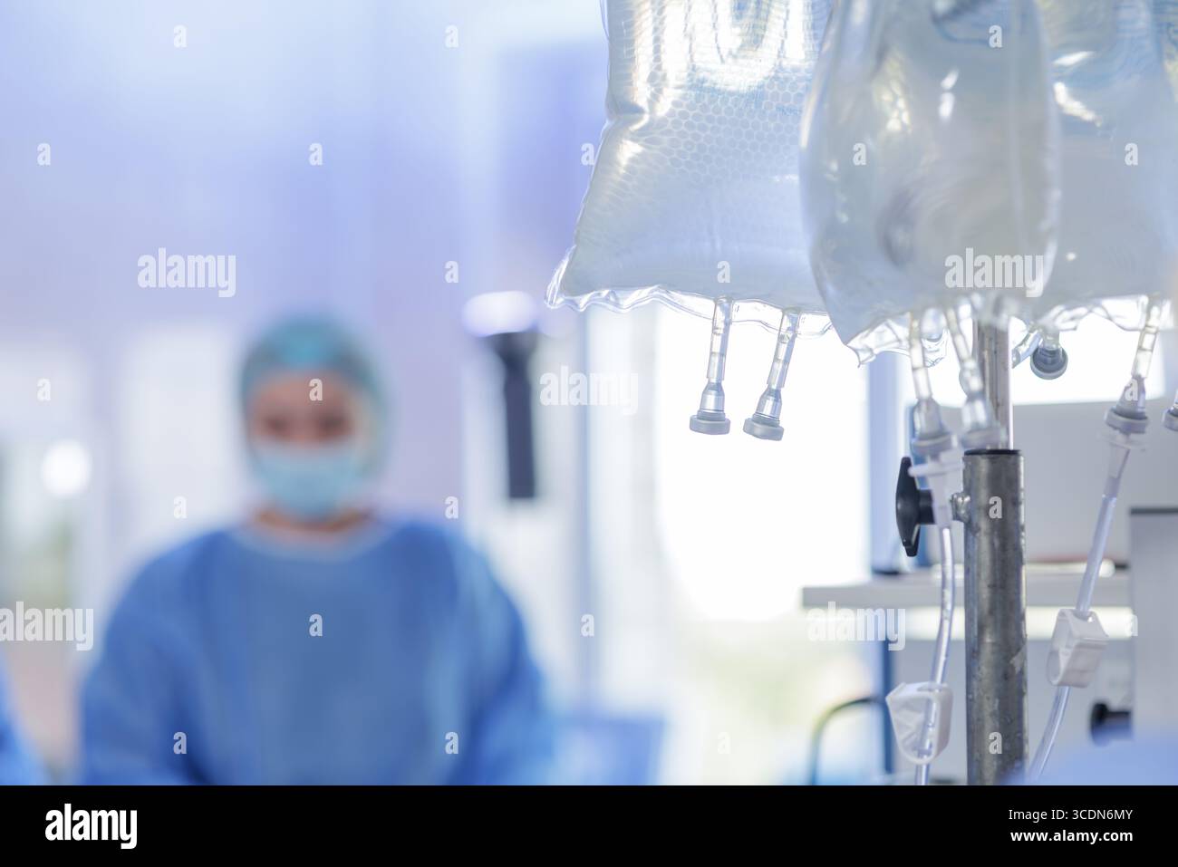 Close view of IV fluid bags on a pole in a sterile operating room with ...