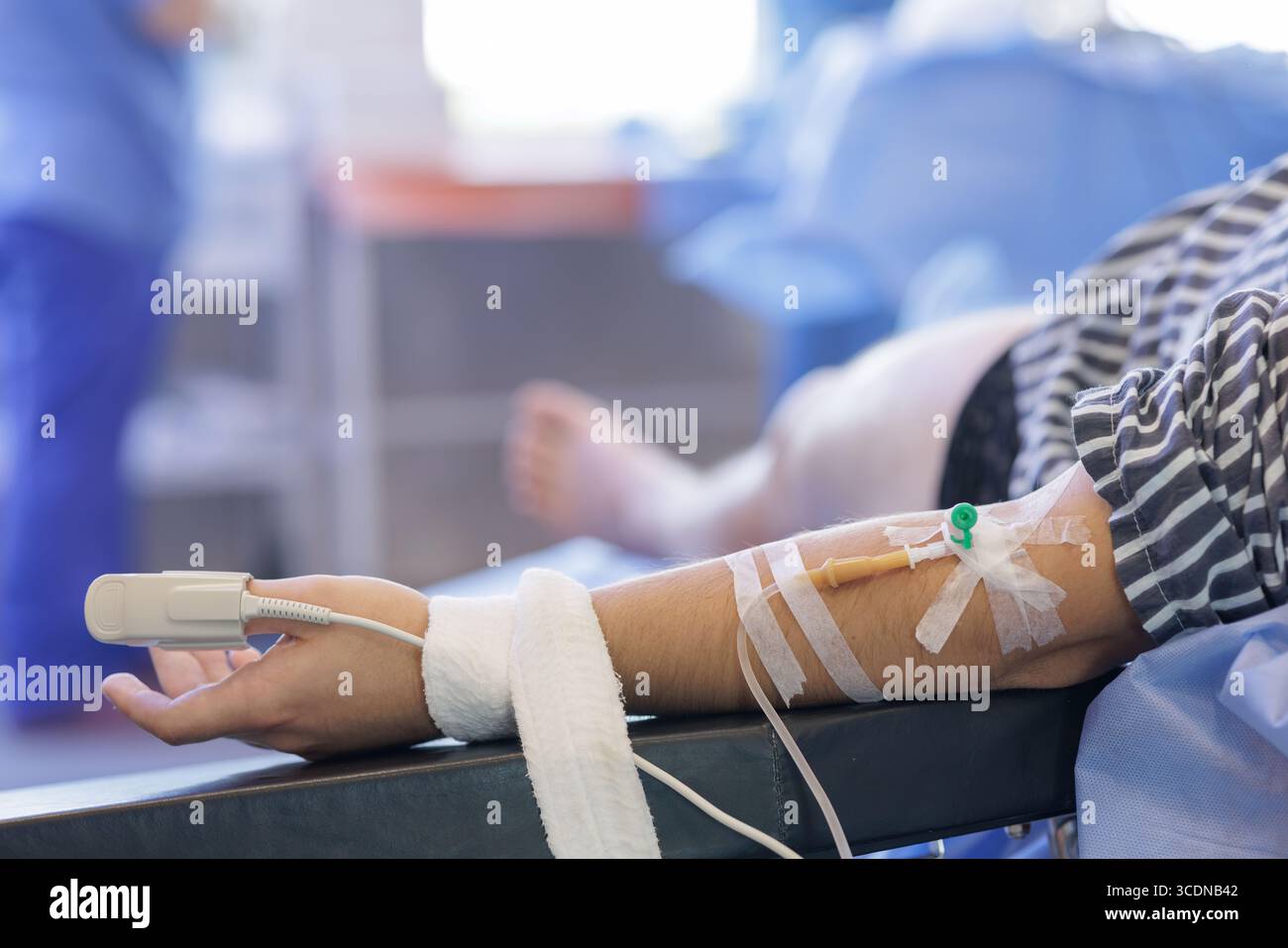 Close view of patient arm with intravenous cannula and fingertip pulse ...