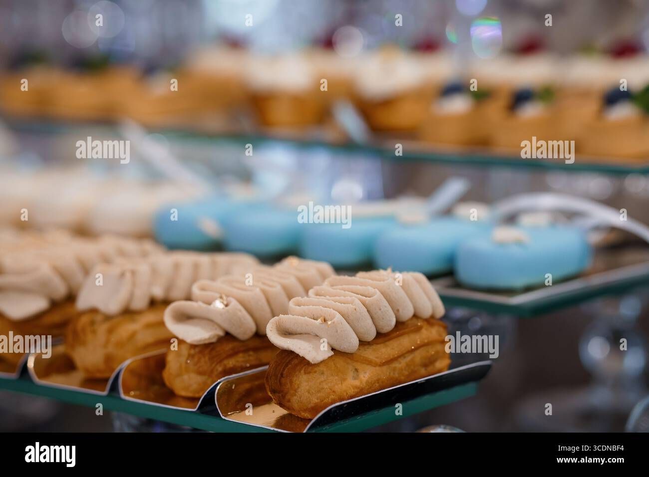 A close-up shot showcases rows of delicate cream puffs with light beige ...