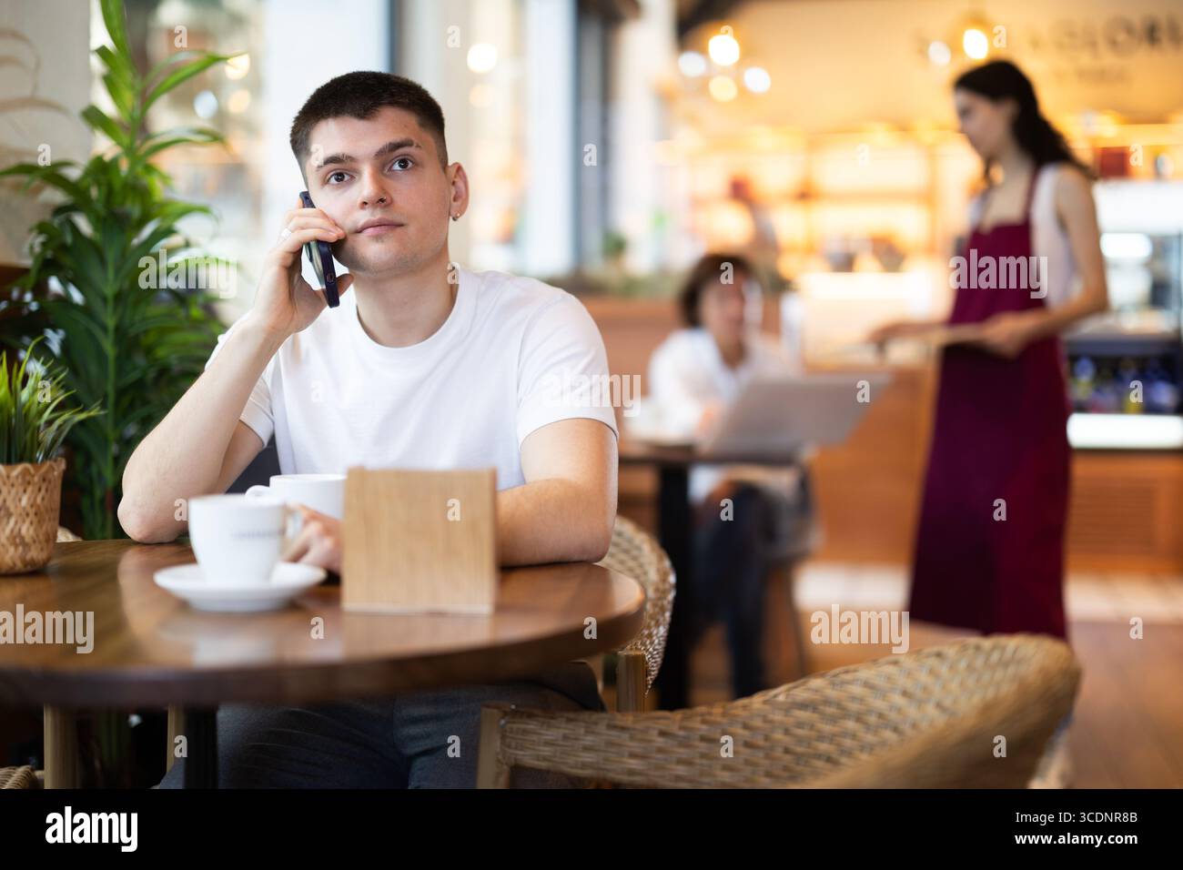 Young man seated in cafeteria hi-res stock photography and images - Alamy