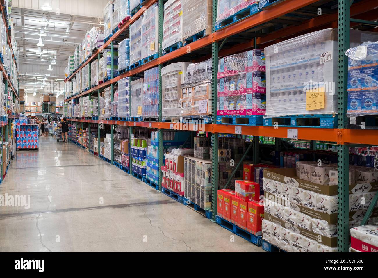 Aisle between industrial shelving stacked with pallets of consumer ...