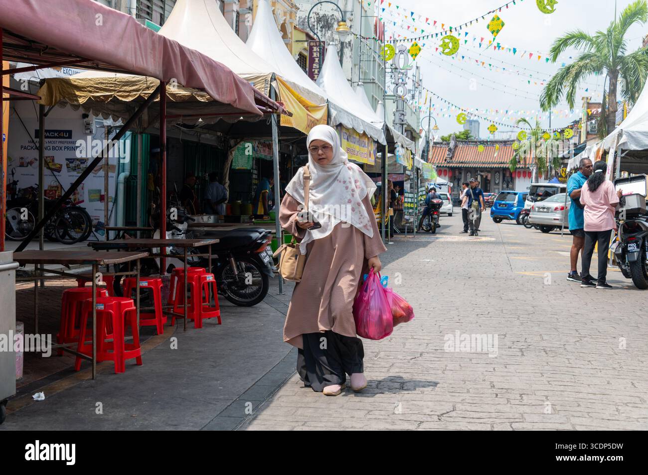 A shopper in a side street in Little India of George Town, capital of ...
