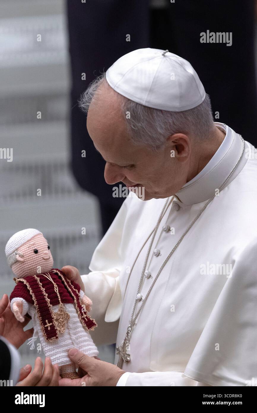 Pope Leo XIV receives a gift of a doll dressed as the Pope from the ...