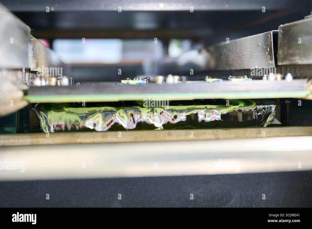 Wave soldering process showing PCB tinning in molten solder bath during ...