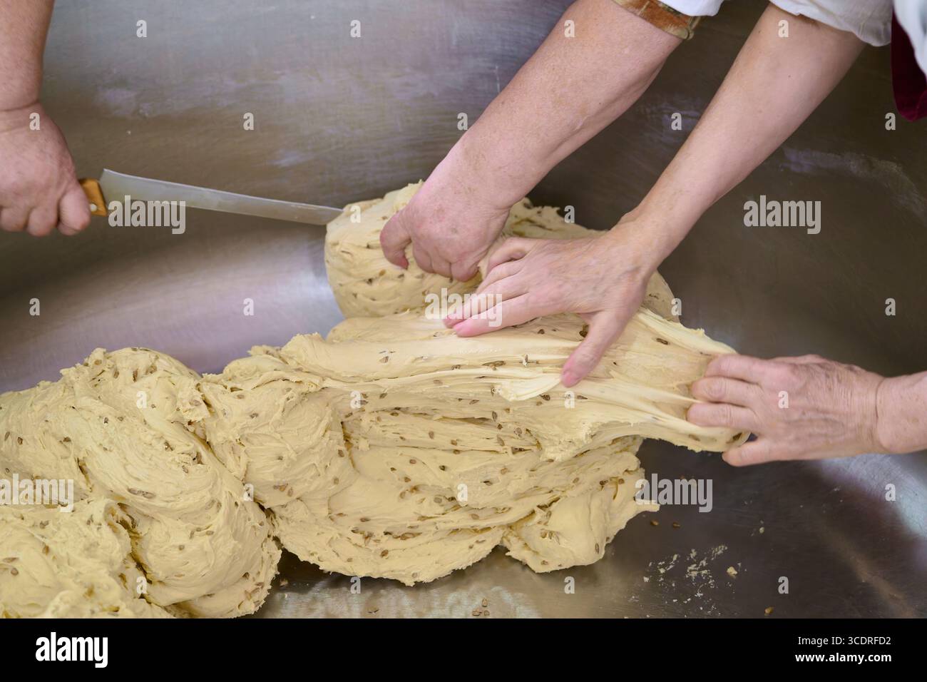 Bakers create artisanal dough in a bustling workshop during the early ...