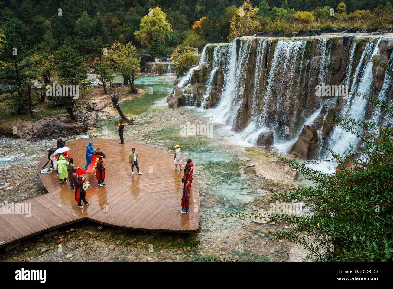 Lijiang, China - Oct 24, 2024: People gather on a wooden deck near a ...