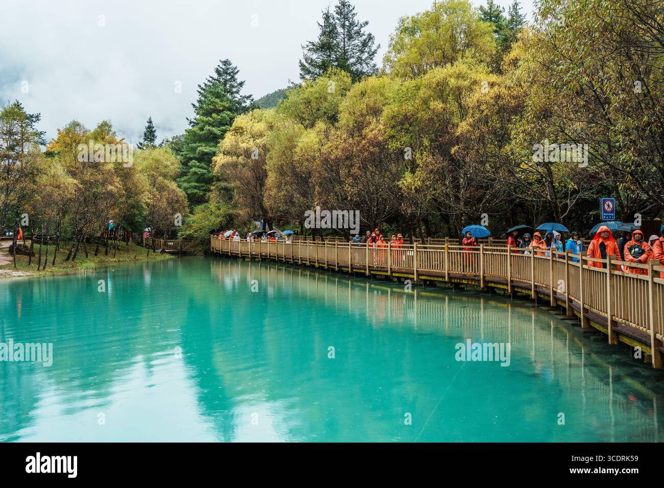 Lijiang, China - Oct 24, 2024: People walk along a boardwalk by the ...