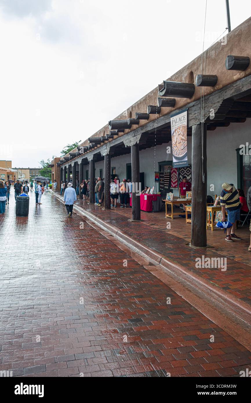 People walking on wet red brick pavers in front of the Palace of the ...
