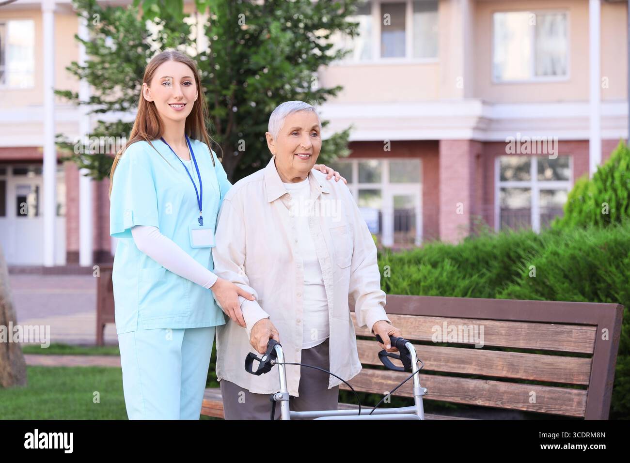 Senior woman with rollator and nurse walking outdoors Stock Photo - Alamy