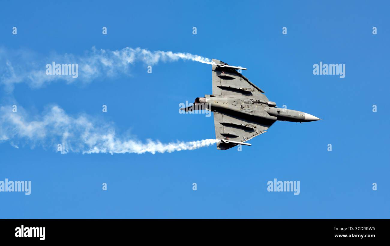 HAL Tejas of Indian Air Force performing aerobatic manoeuvre with smoke ...