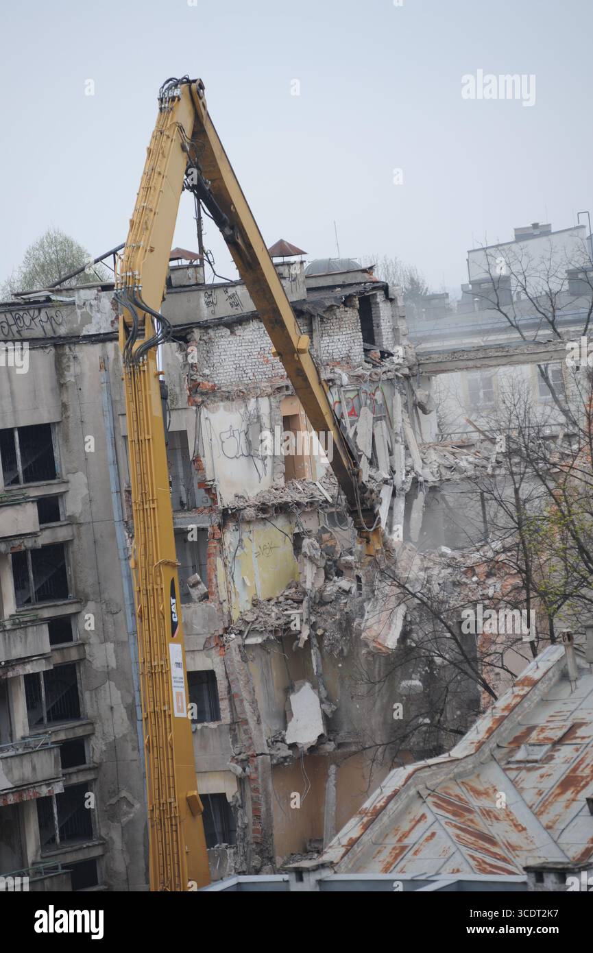 Demolition of a building in deconstruction site with crane, machinery ...