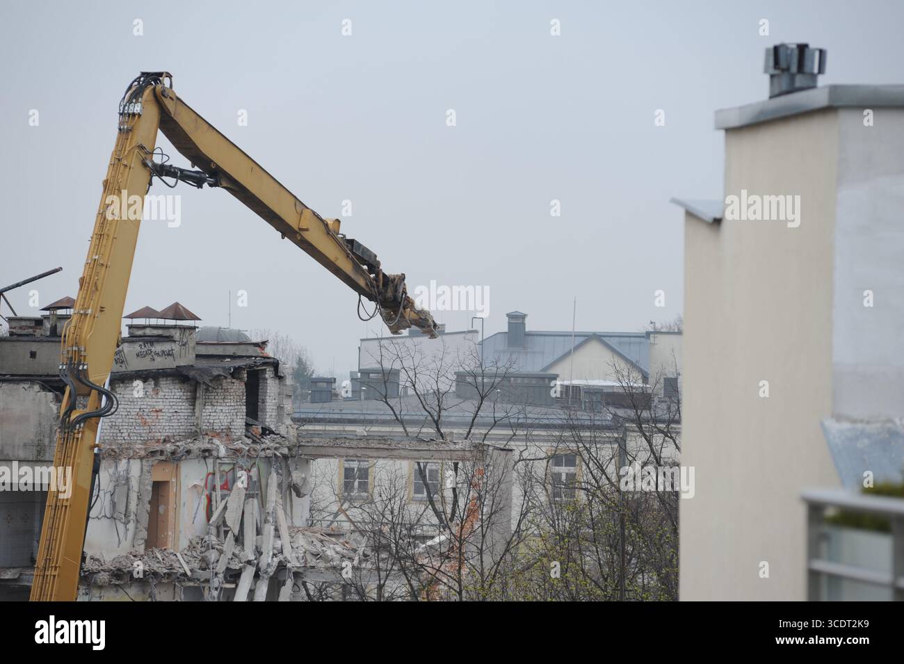 Demolition of a building in deconstruction site with crane, machinery ...