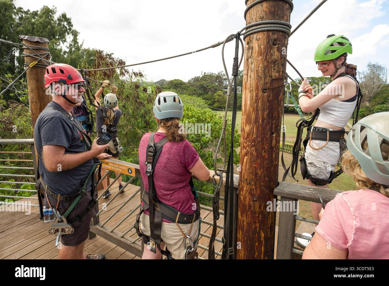 Guide attaching pully to cable and checking safety equipment during a ...