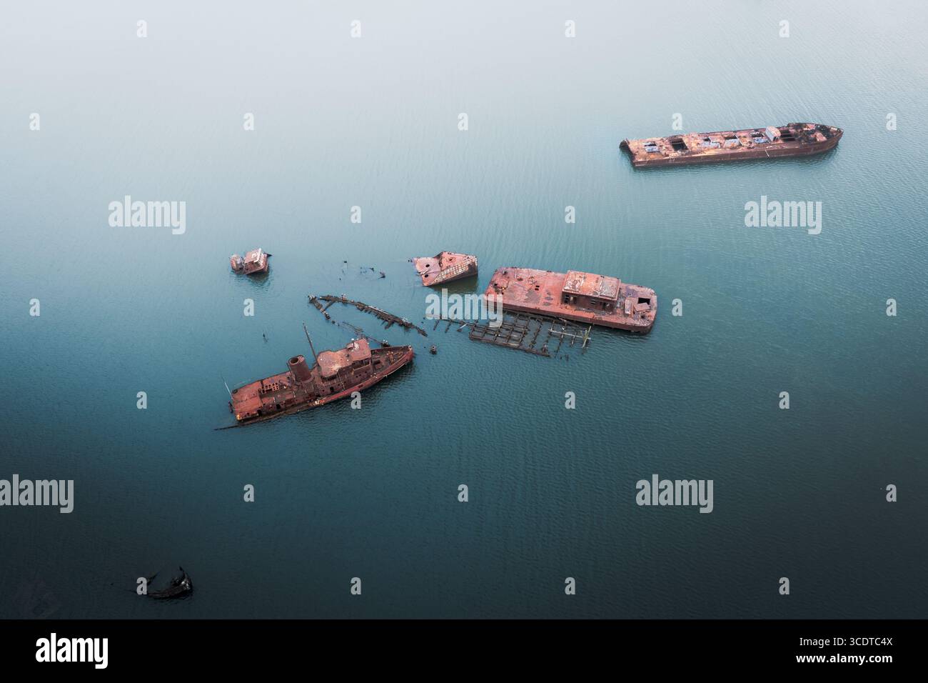 Aerial view of decaying shipwrecks, their rusted hulls contrasting ...