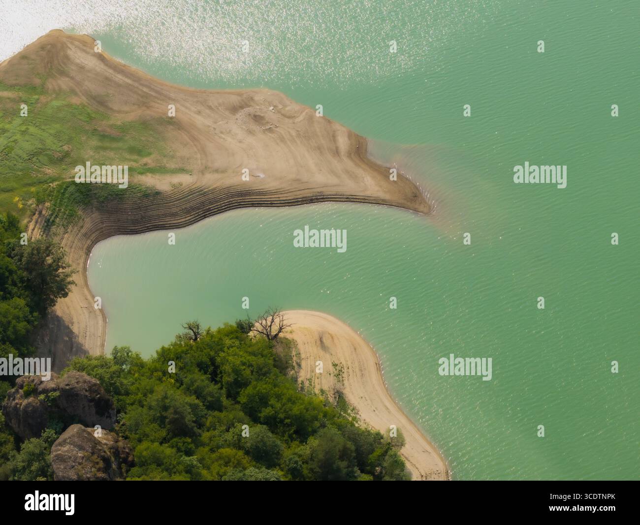 Aerial view of the Algeti Reservoir's turquoise waters meet the stark contrast of the arid ...