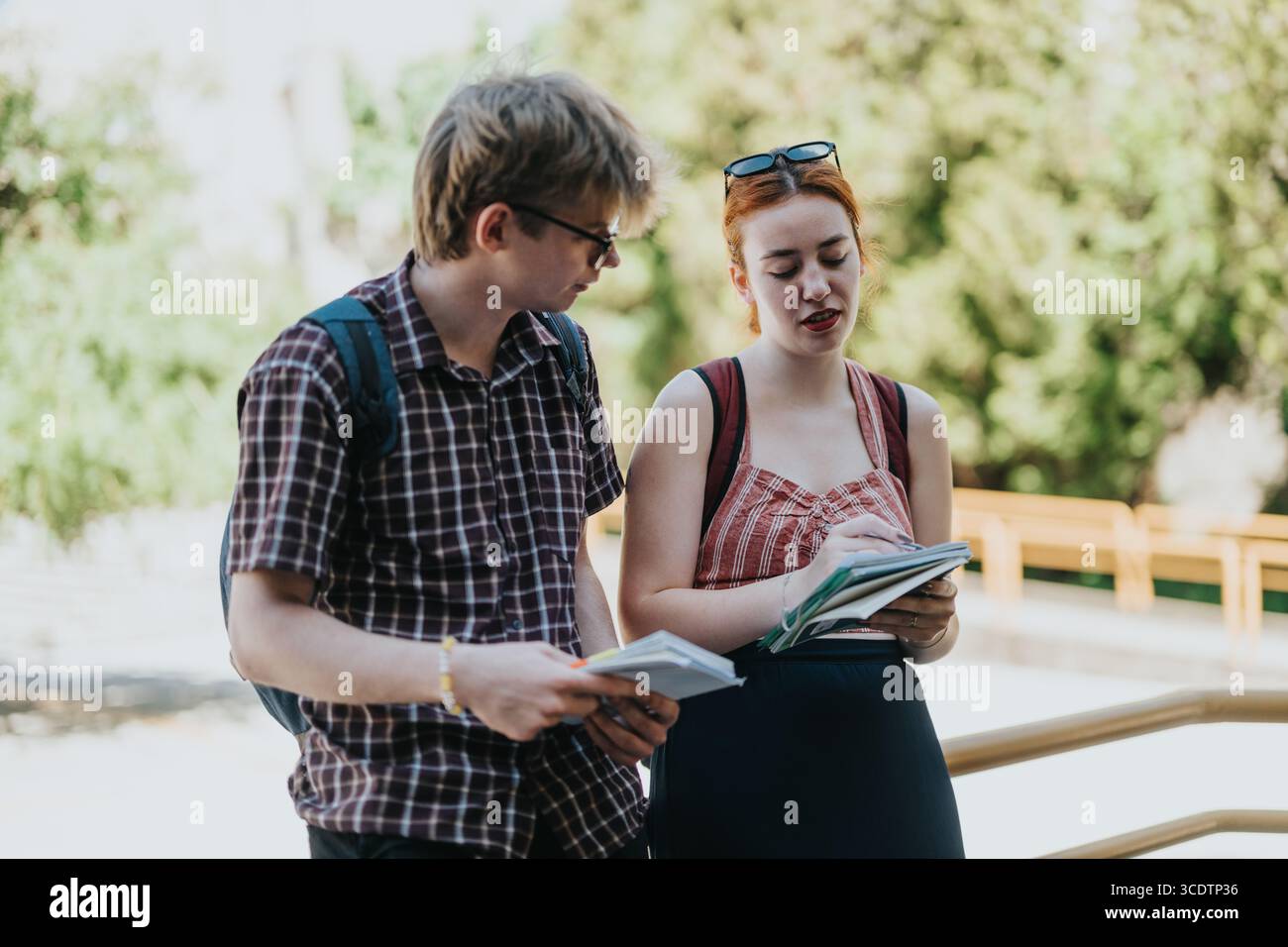 Students reviewing notes together in an outdoor courtyard setting Stock ...