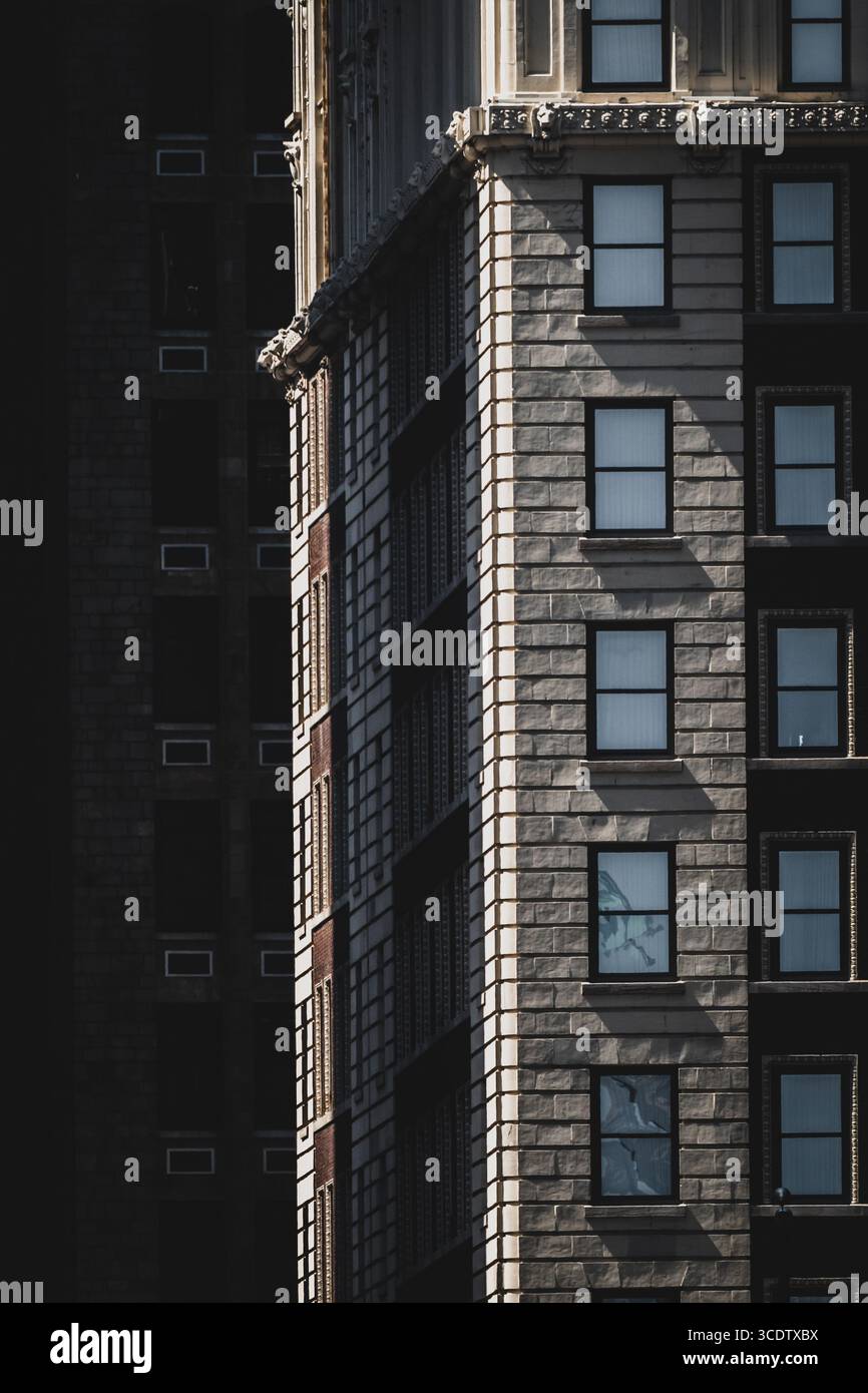 View of light playing on the textured facade of a tall building with ...