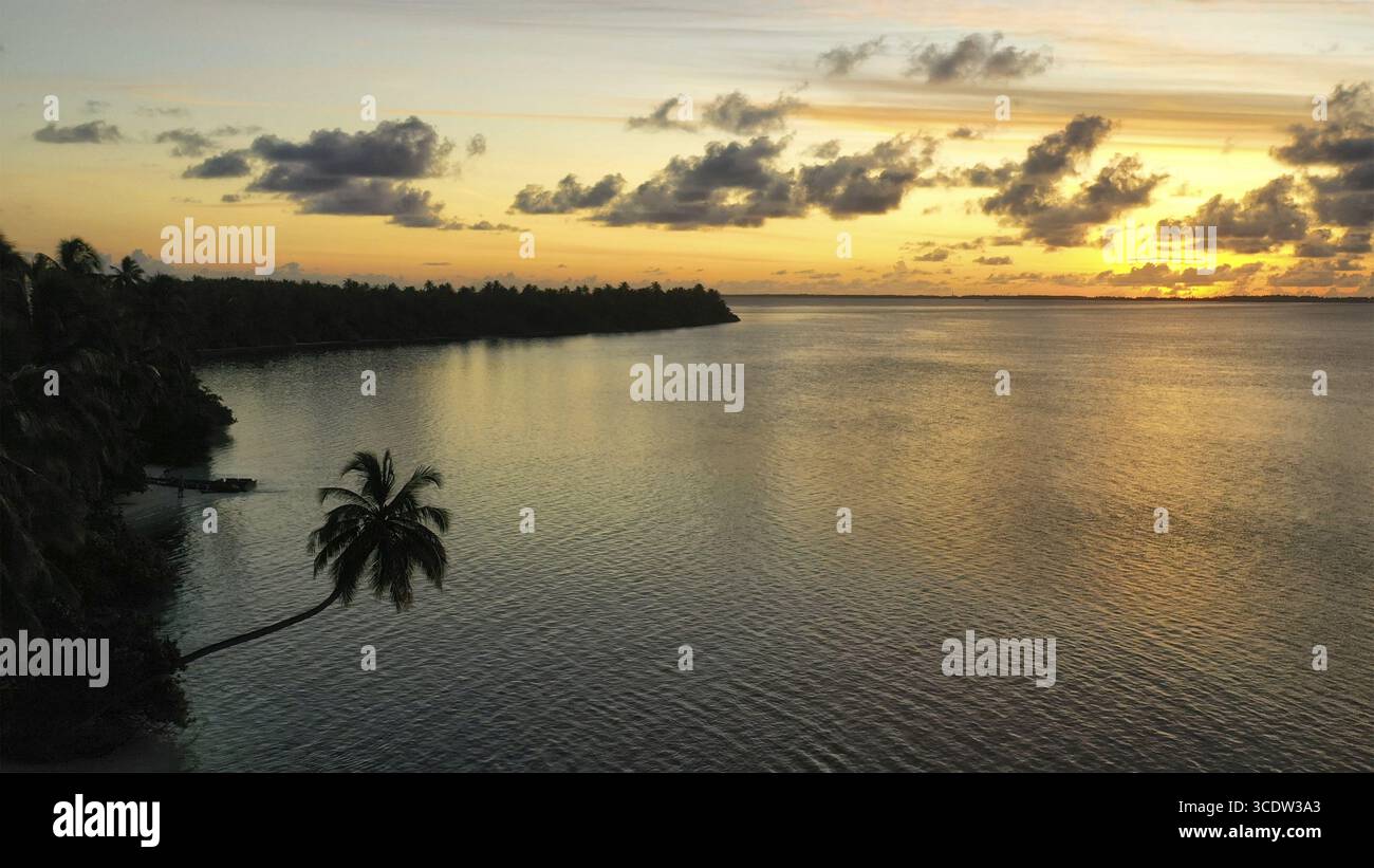 Aerial view of the sun dipping below the horizon, painting the tranquil ...