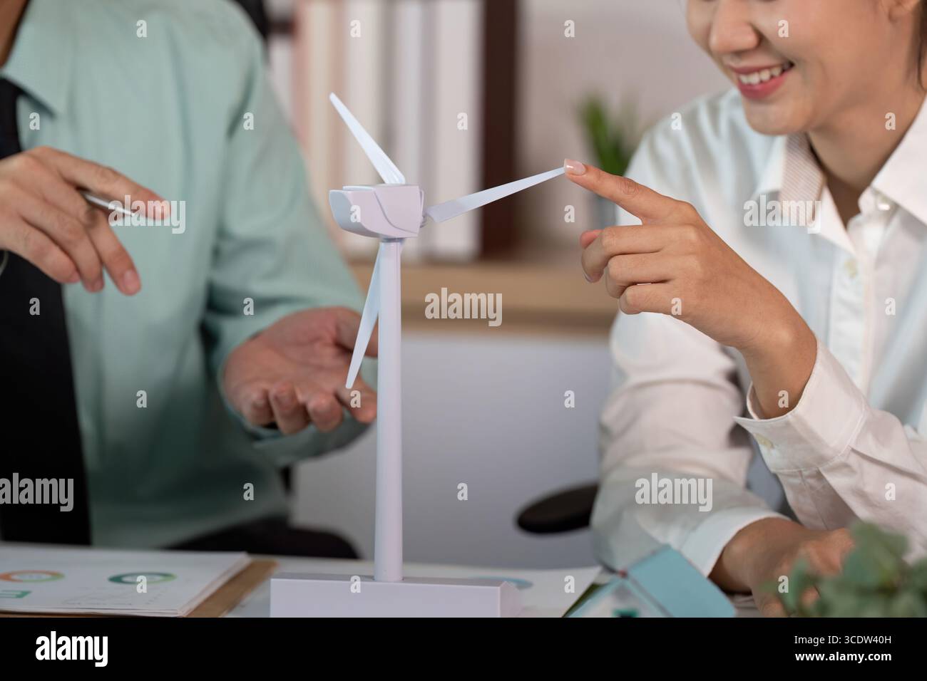 ESG discussion with wind turbine model in office setting Stock Photo ...