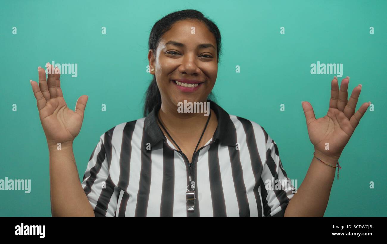 Referee raises hands beside head wearing black and white striped jersey ...