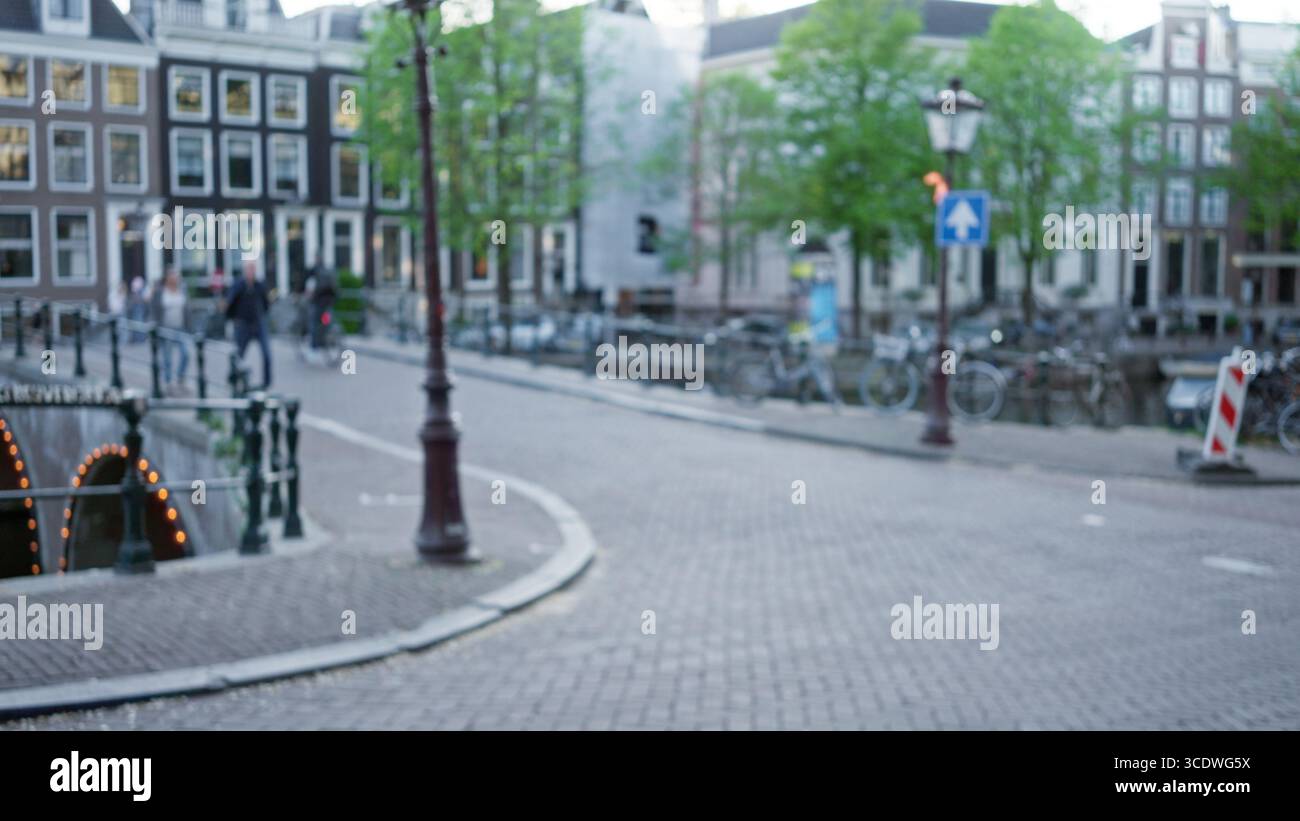 Blurred street scene in amsterdam shows defocused cityscape with bokeh ...
