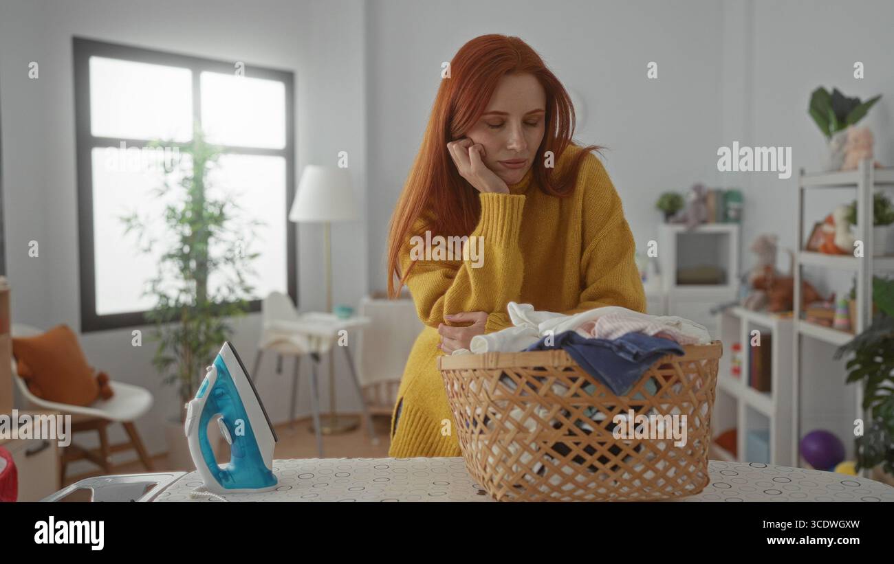Redhead woman sorting laundry in home laundry room with wicker basket ...