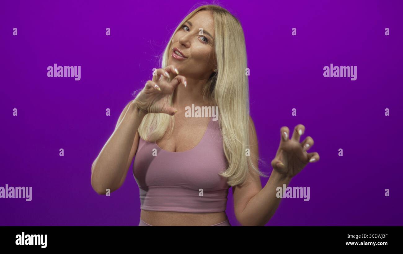 Blonde woman smiling showing expressive hands shaped as claws in purple ...