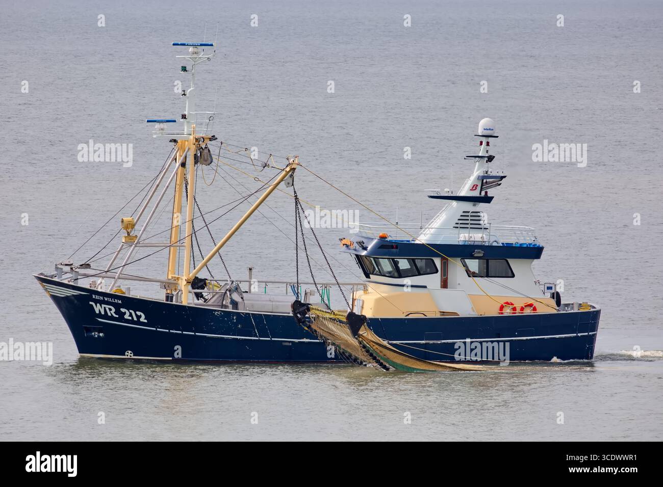 Blue and yellow fishing trawler on the North Sea off the Dutch coast ...