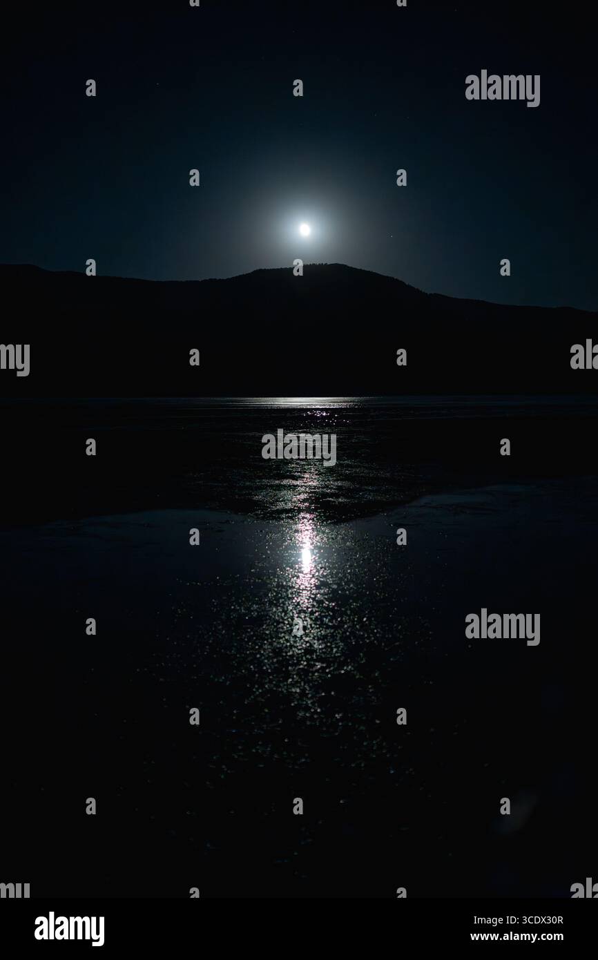 Full moon shining over lake with dramatic water reflection Stock Photo ...