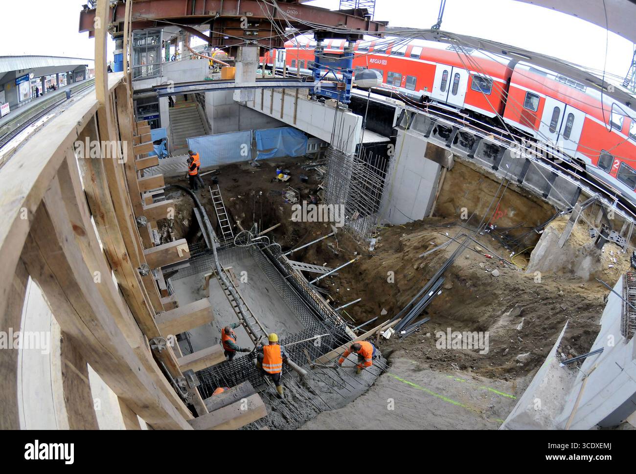 Construction at Münster railway station with workers installing rebar and pouring concrete for ...