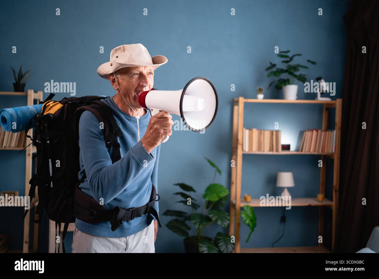 Retired traveler with backpack Screaming in megaphone at home. sincere ...