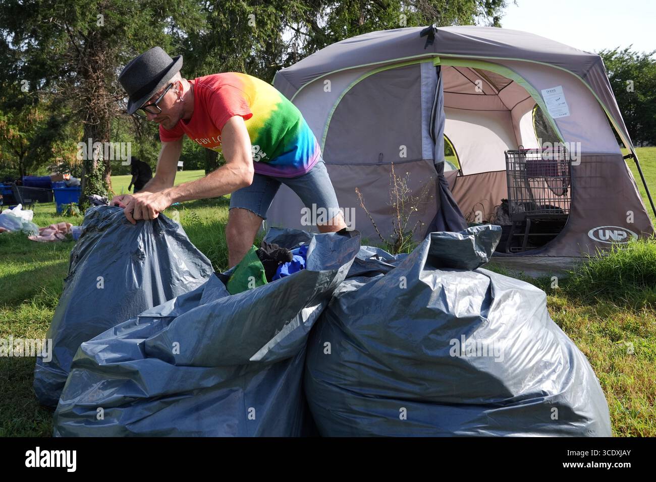 Jesse Wall, 43, clears up a tent encampment, Thursday, Aug. 14, 2025 ...