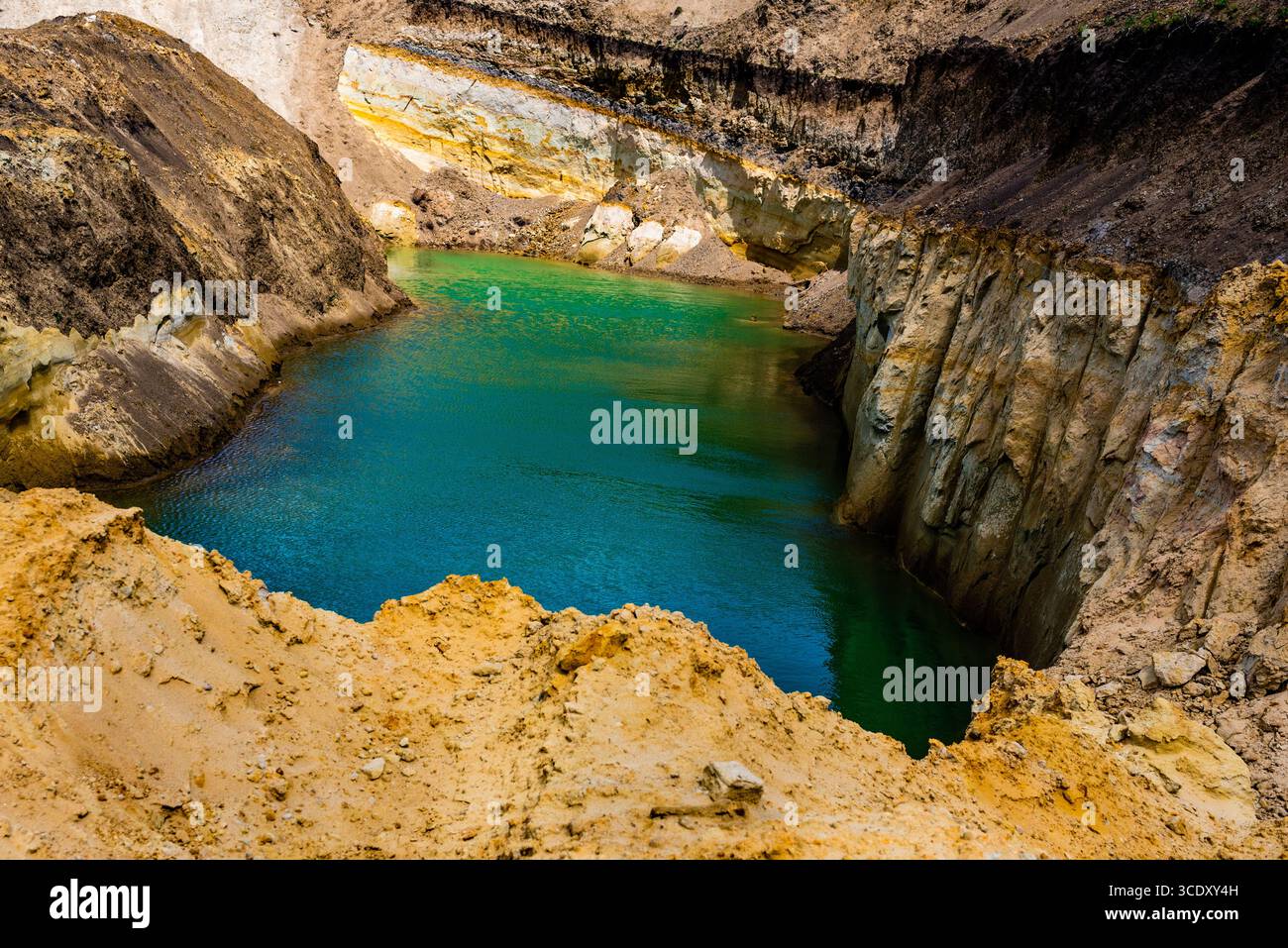 Sand quarry filled with water reflecting the cloudy sky, creating an ...