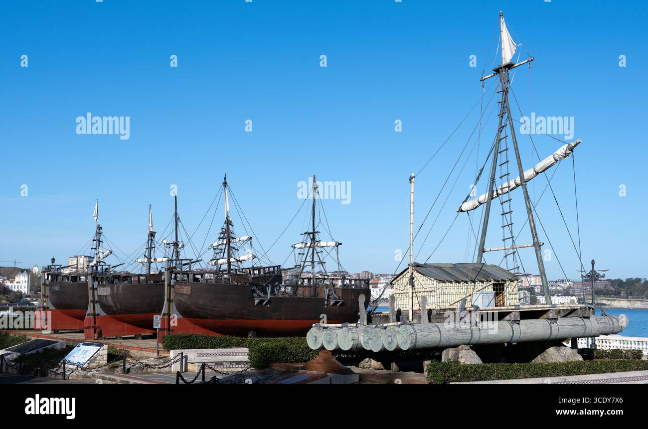 Replica of historic ships docked at a waterfront under a clear blue sky ...