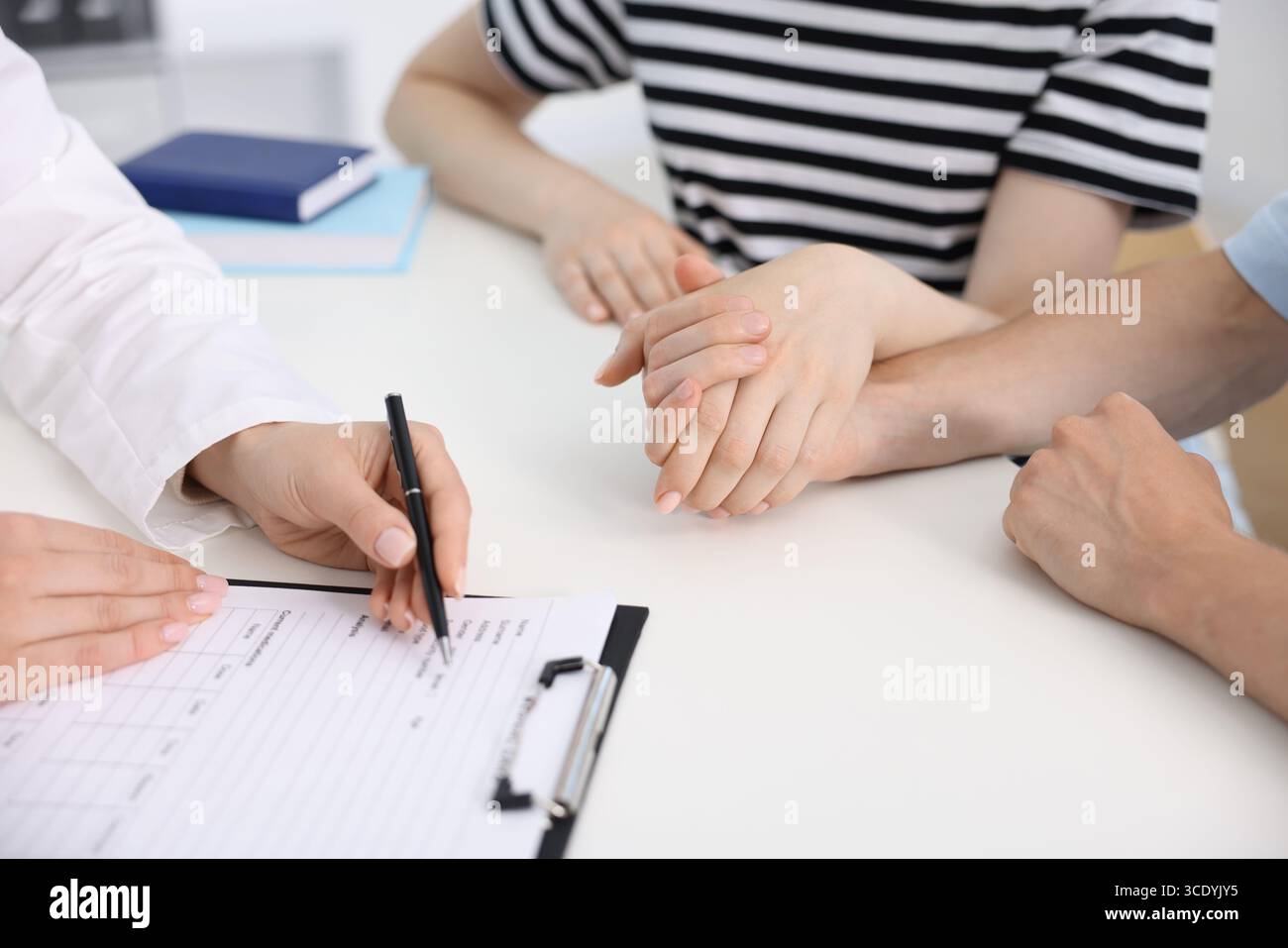 In vitro fertilization (IVF). Couple holding hands during appointment ...