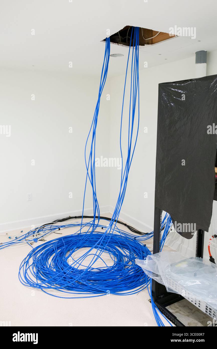 Long bundle of six Cat-6A ethernet cables being pulled through interior ...