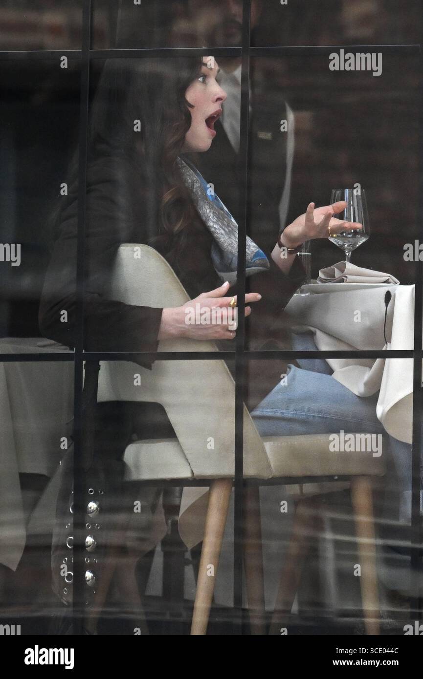 Actress Anne Hathaway seen in the window of a restaurant filming for ...