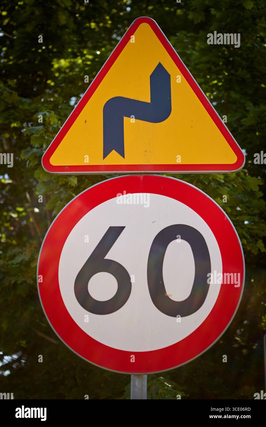 Traffic warning sign indicating winding road and 60kmh speed limit ...