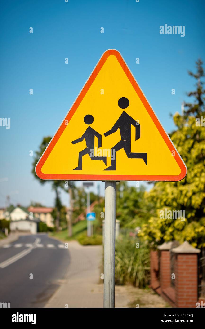 A triangular warning sign for children crossing. Photographed outdoors ...