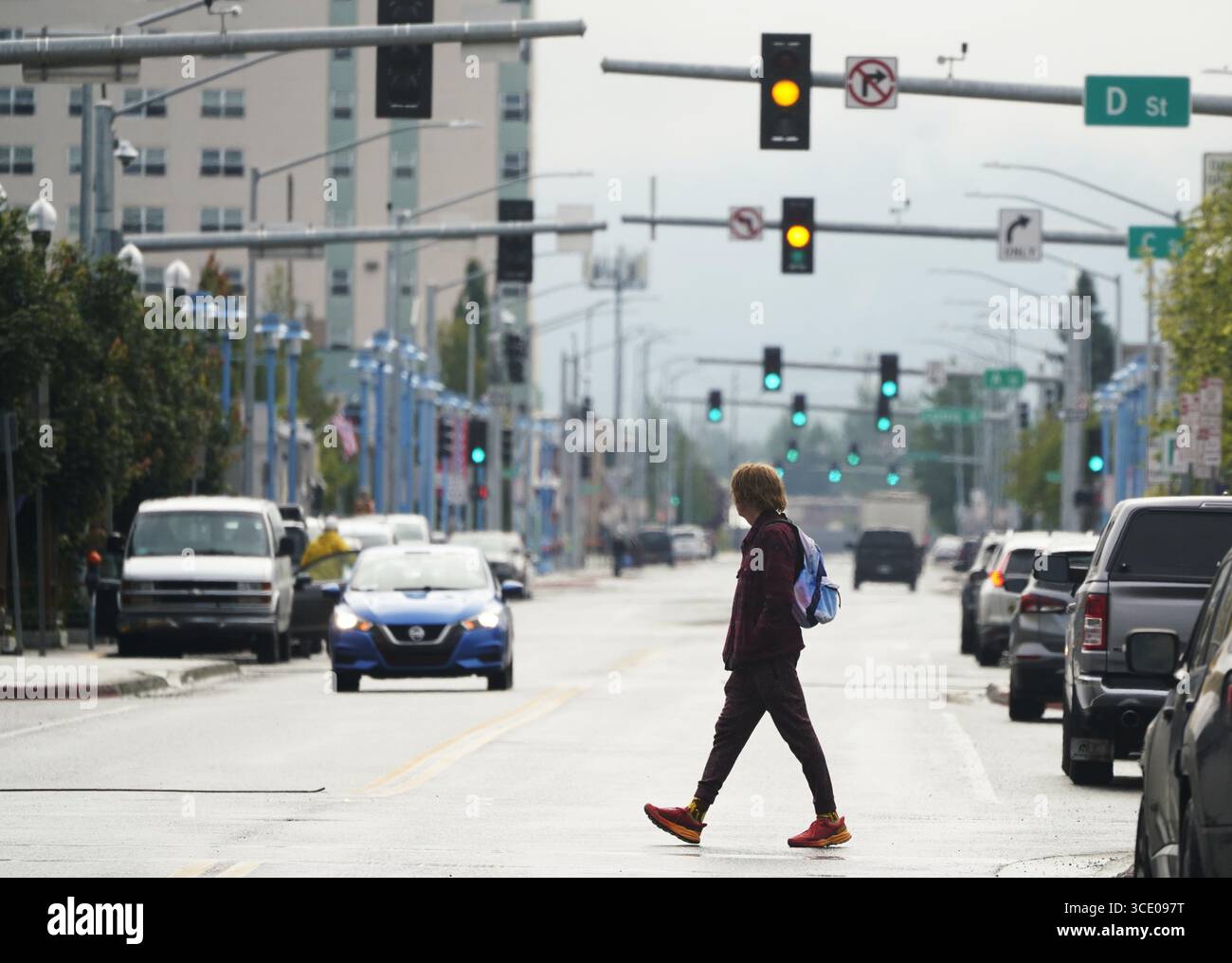 Anchorage, USA. 14th Aug, 2025. A man walks across a street in ...